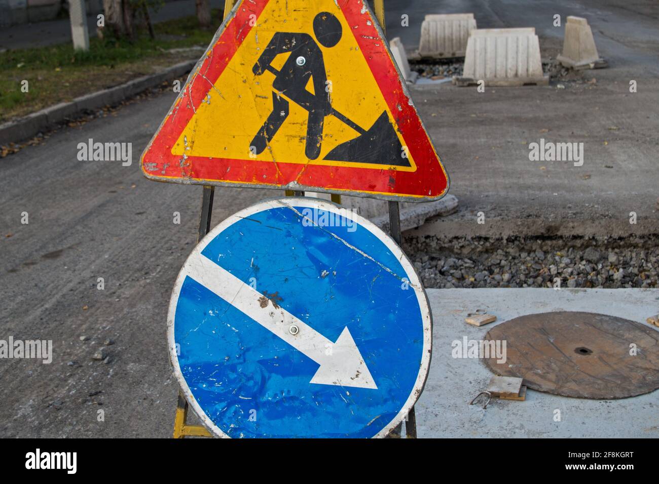 Metal tripod with attached shabby scratched signs of road works and ...