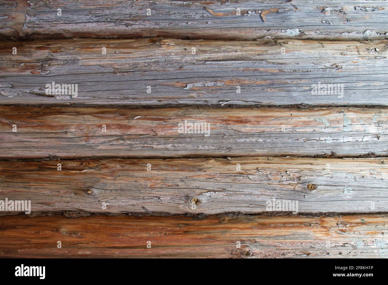 A fragment of a log wall, horizontally placed old logs with traces of ...