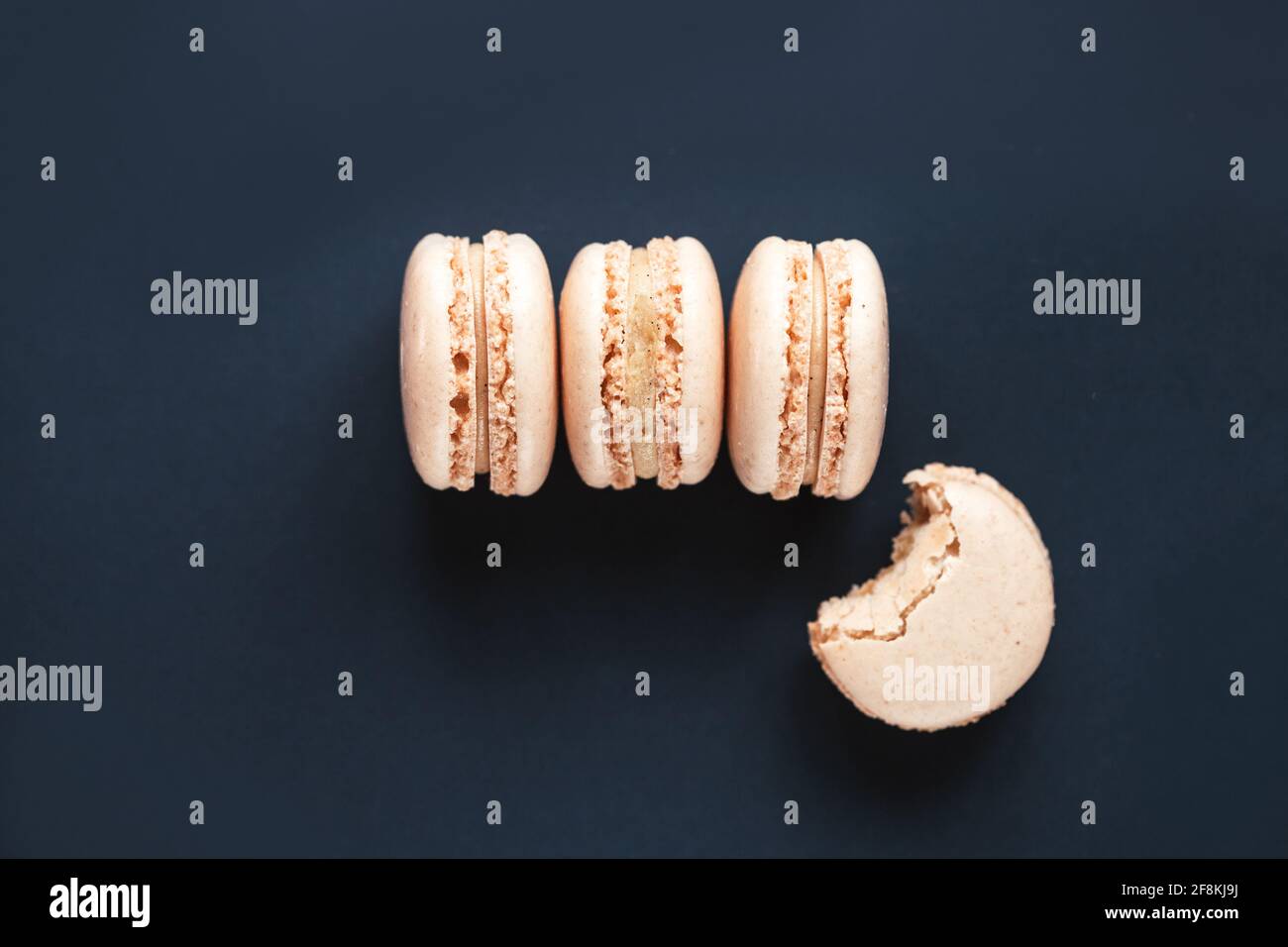 Light cream and chocolate macaroons on black background Stock Photo - Alamy