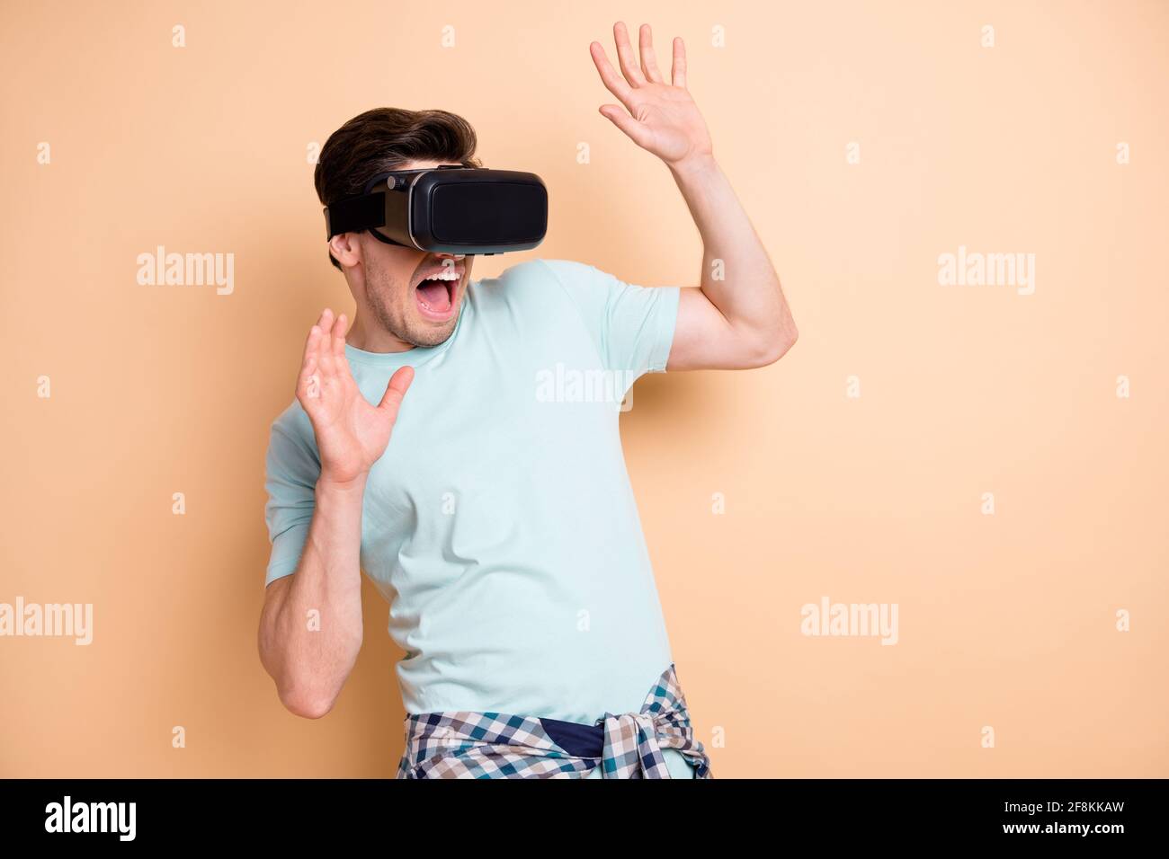 Portrait of nice terrified guy wearing vr helmet feeling fear exploring ...