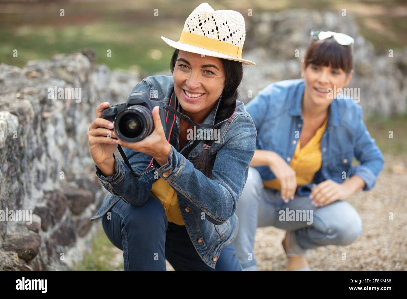 two female photographer crouching near a wall Stock Photo - Alamy