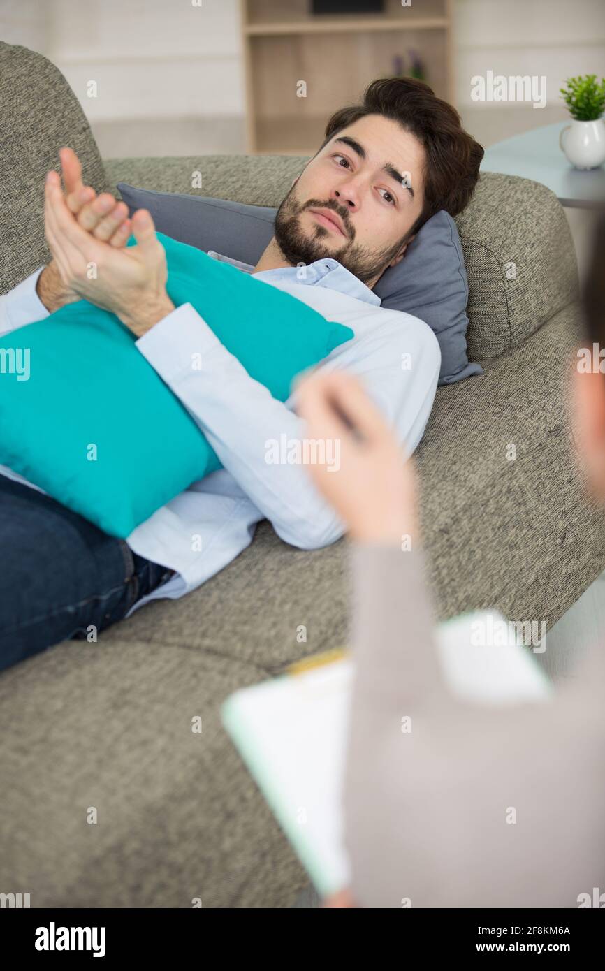 ompetent psychologist sitting opposite his patient while discussing ...