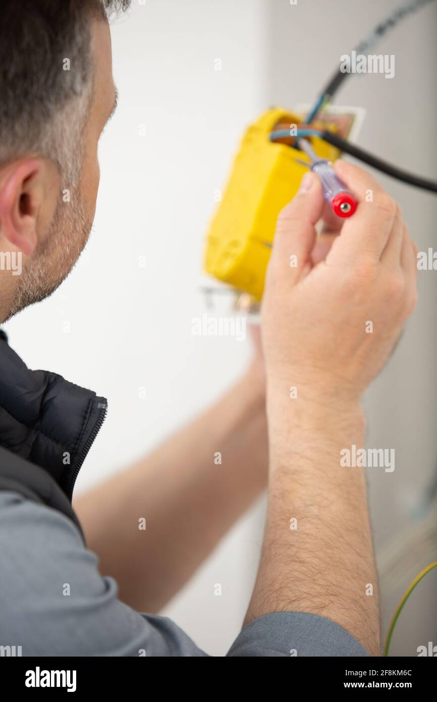 electrician installing an electrical switch in a new house Stock Photo ...