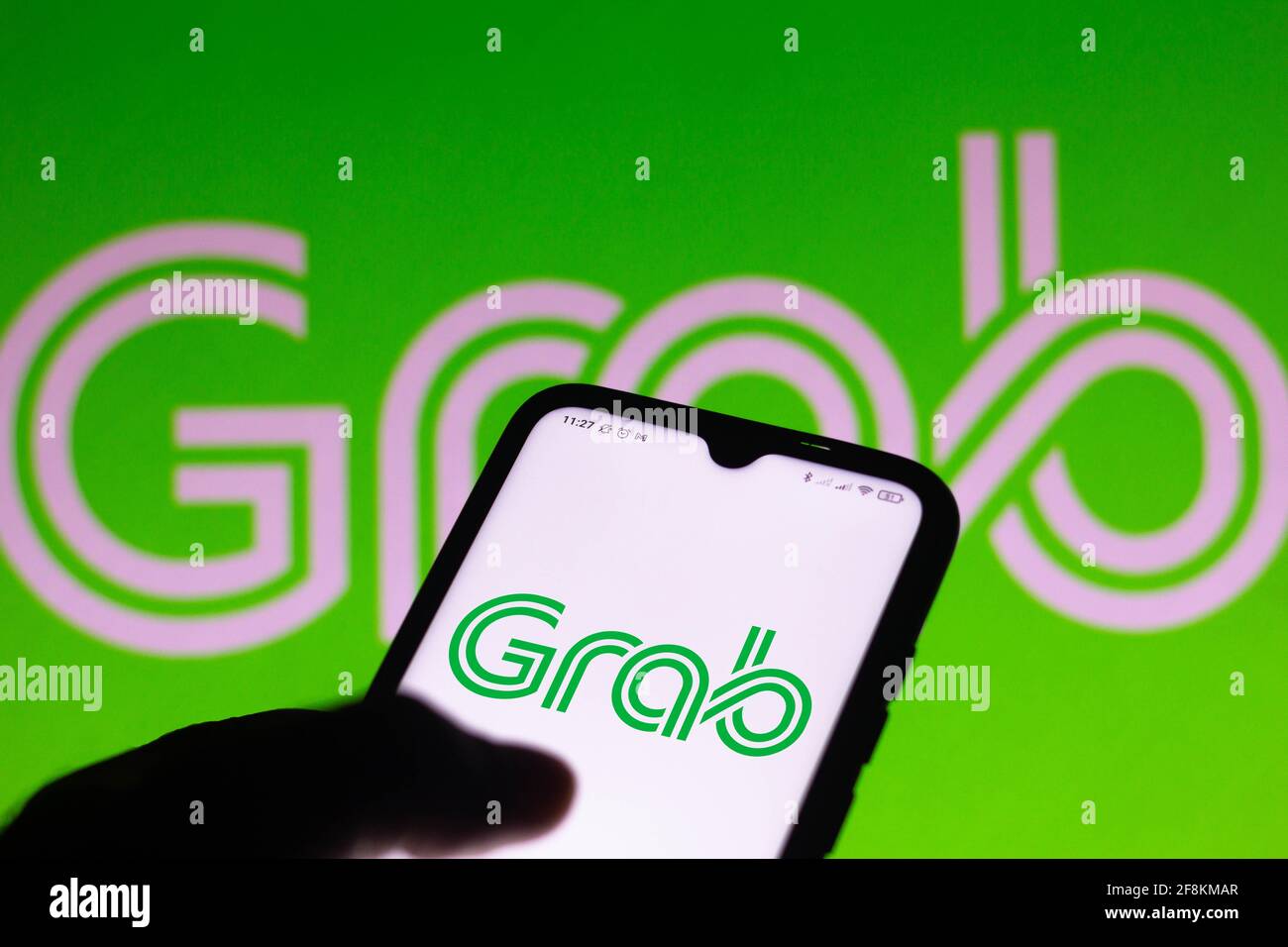 In this photo illustration, the Grab Holdings logo seen displayed on a ...