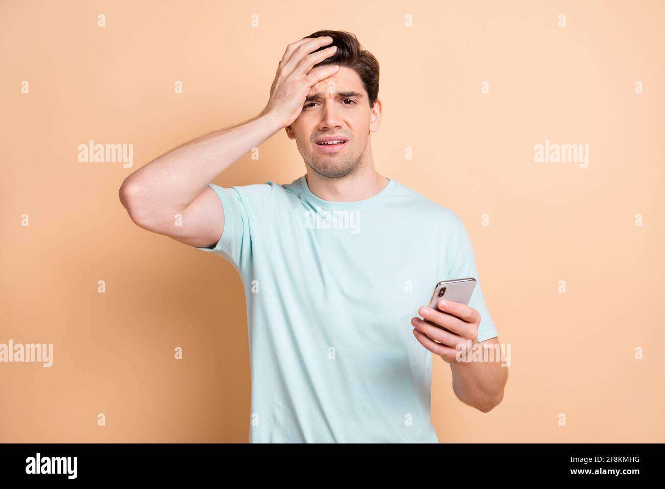 Portrait of disappointed guy influenzer using device browsing media ...