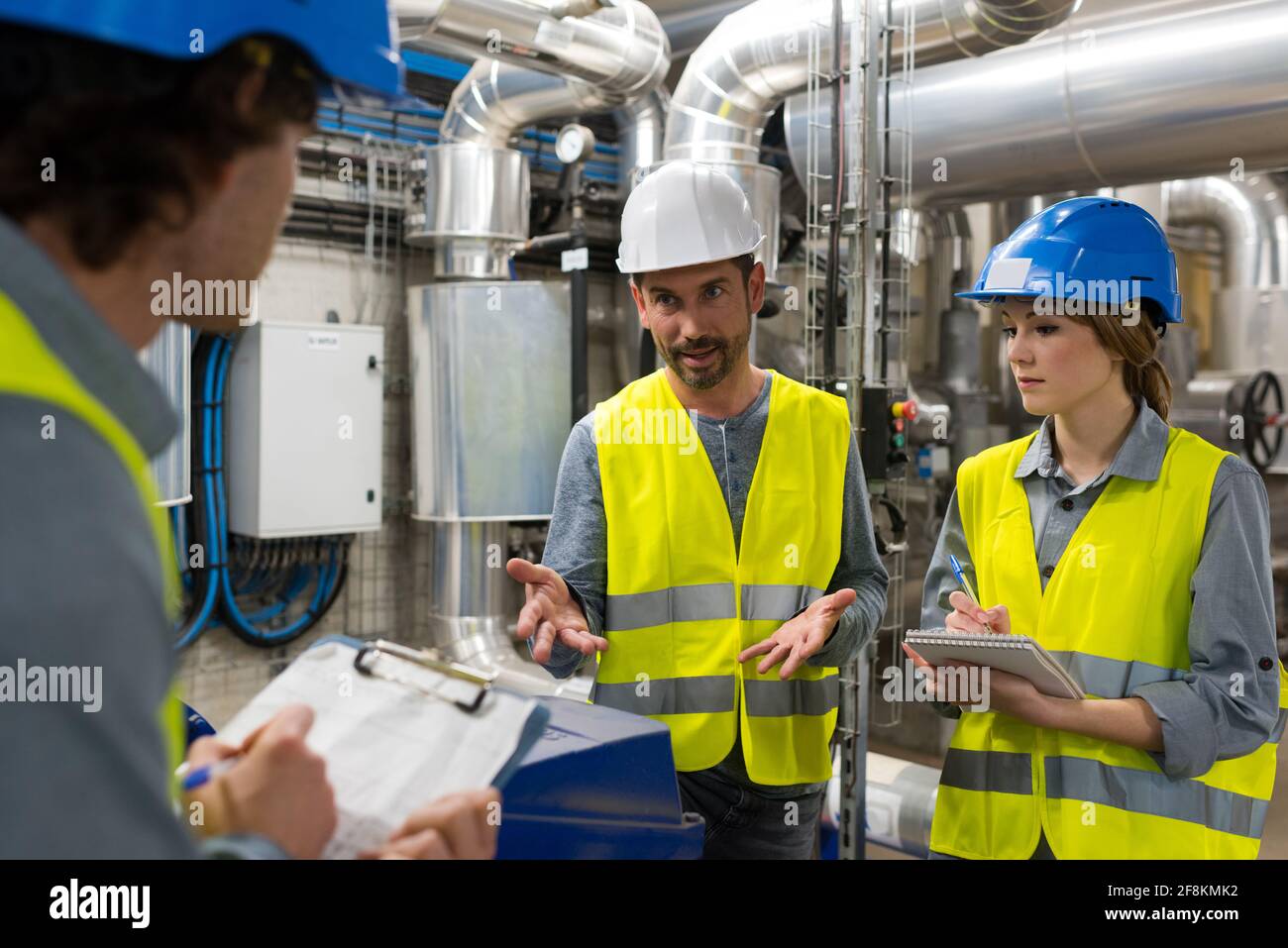 three engineers talking in a factory Stock Photo - Alamy