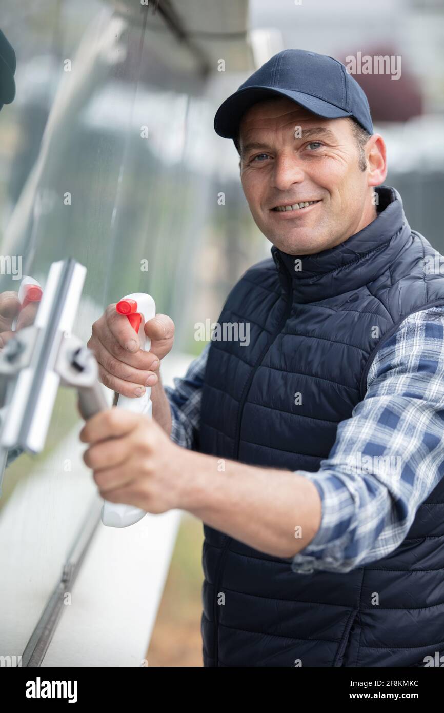 male worker washing window glass from outside Stock Photo - Alamy