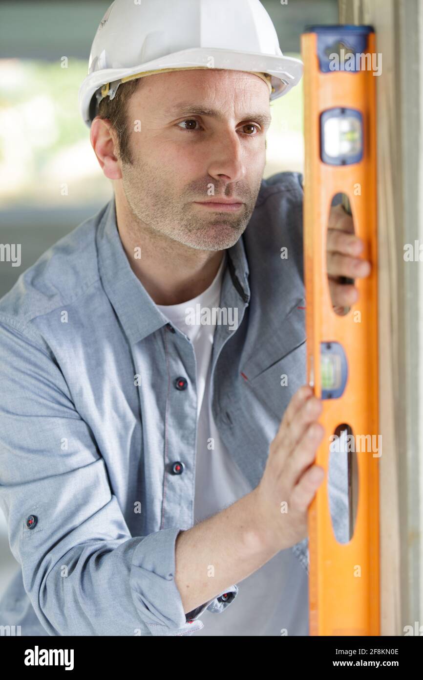 worker using spirit level on a wooden door frame Stock Photo - Alamy