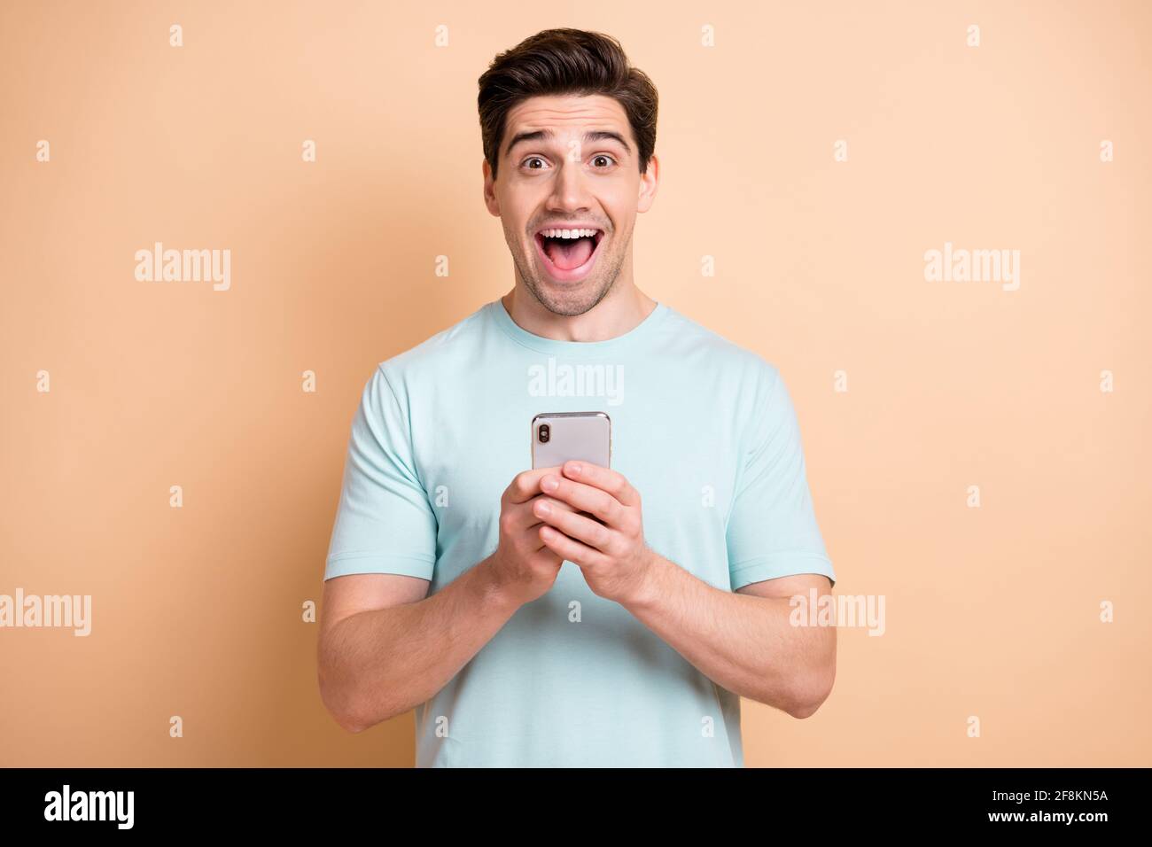 Portrait of nice cheerful amazed addicted guy blogger using gadget ...