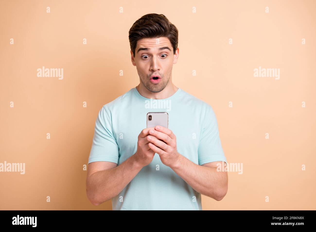 Portrait of nice stunned focused guy blogger using device browsing ...