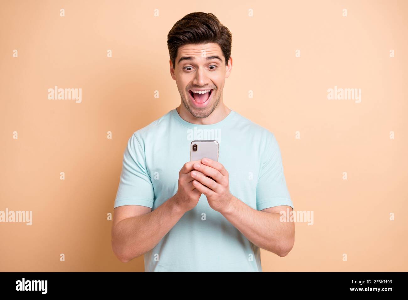 Portrait of nice cheerful focused guy blogger influenzer using device ...