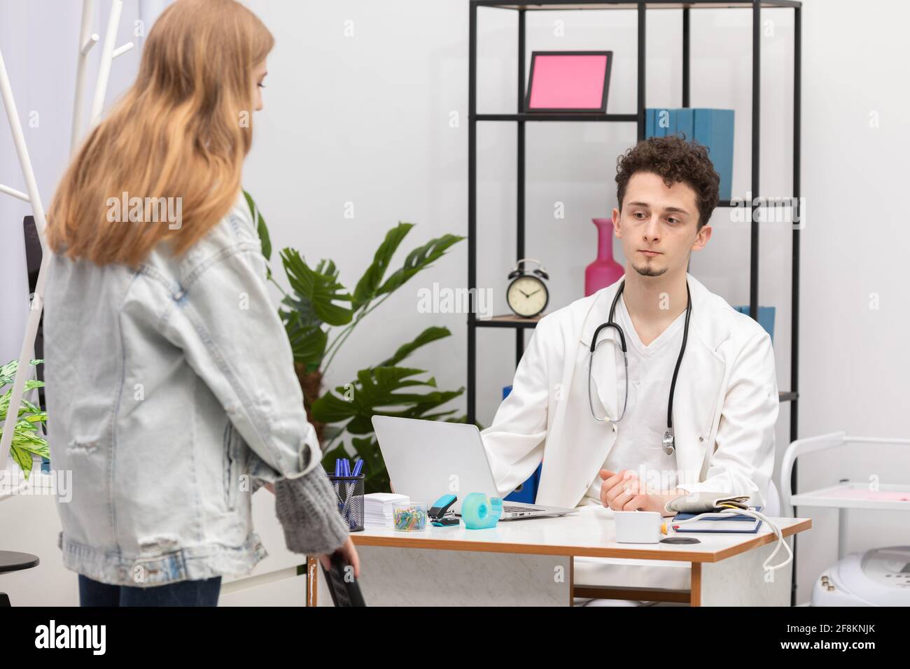 The doctor invites the patient to sit down and conducts an initial ...