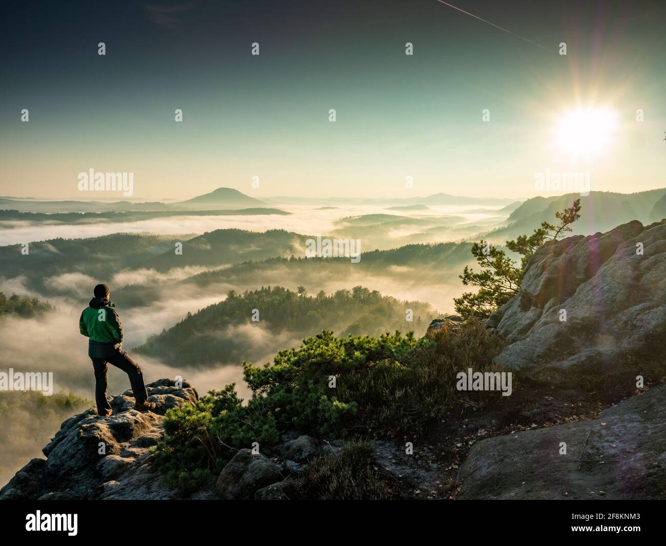 Single man hiker on a mountain trail. Mountain look into misty valley ...