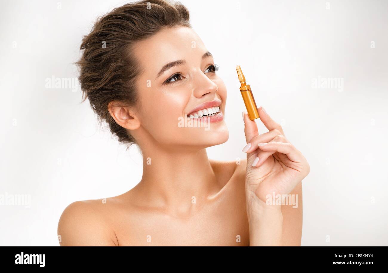 Happy woman holds ampoule with serum for hair or skin care. Photo of ...