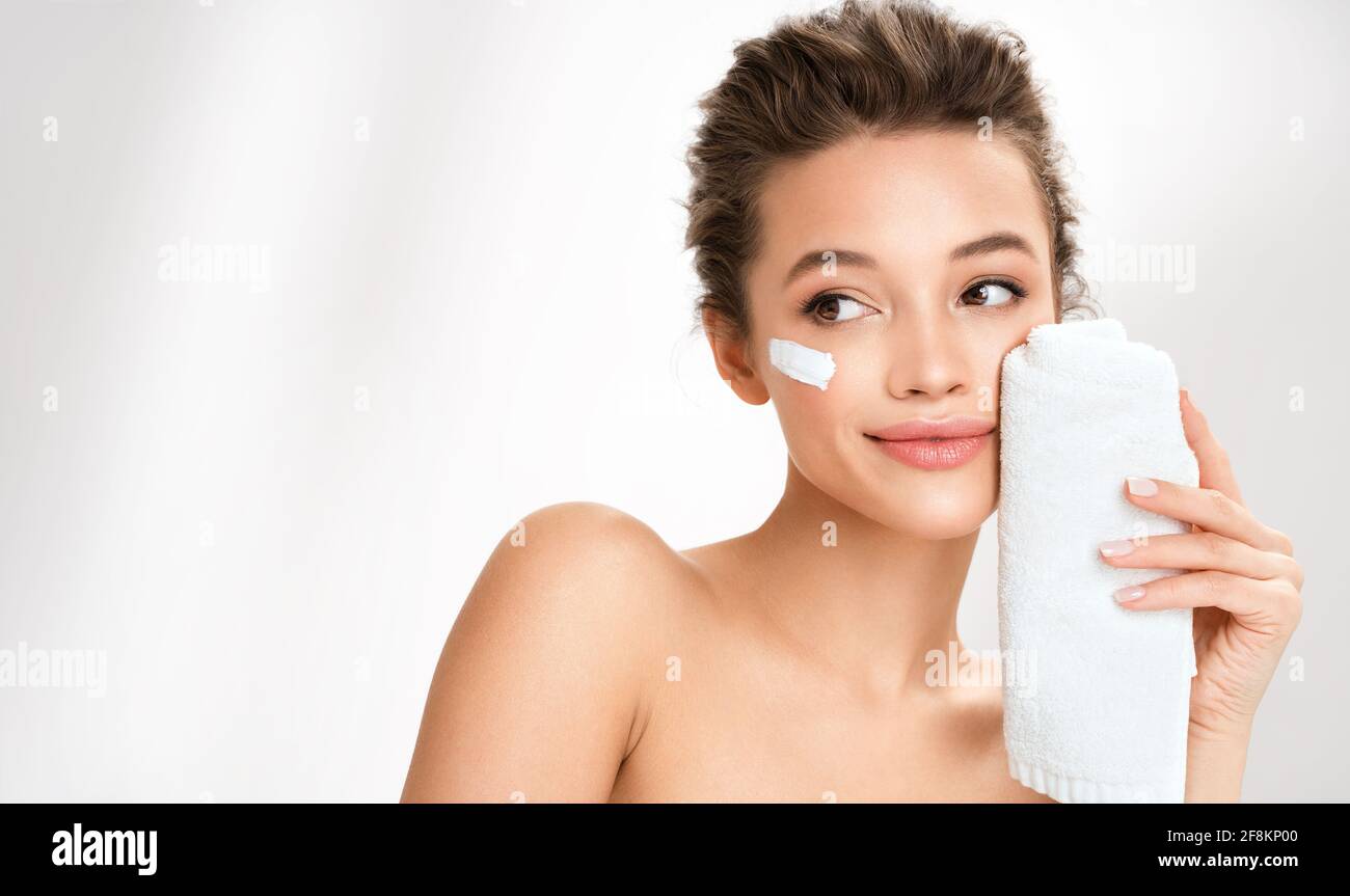 Woman wiping facial skin with towel, removing cream. Photo of woman ...