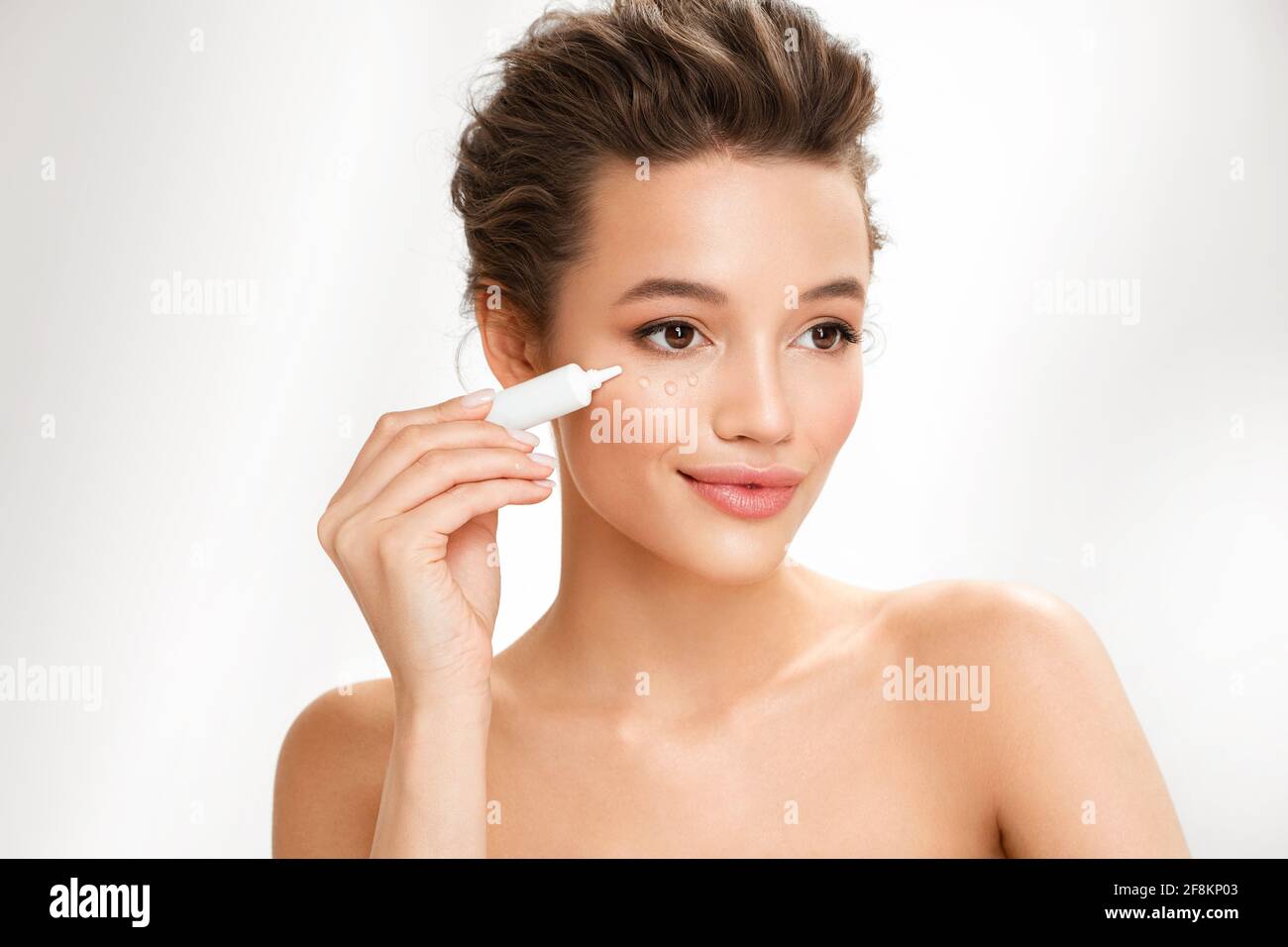 Beautiful woman using cream around the eyes. Photo of woman with ...