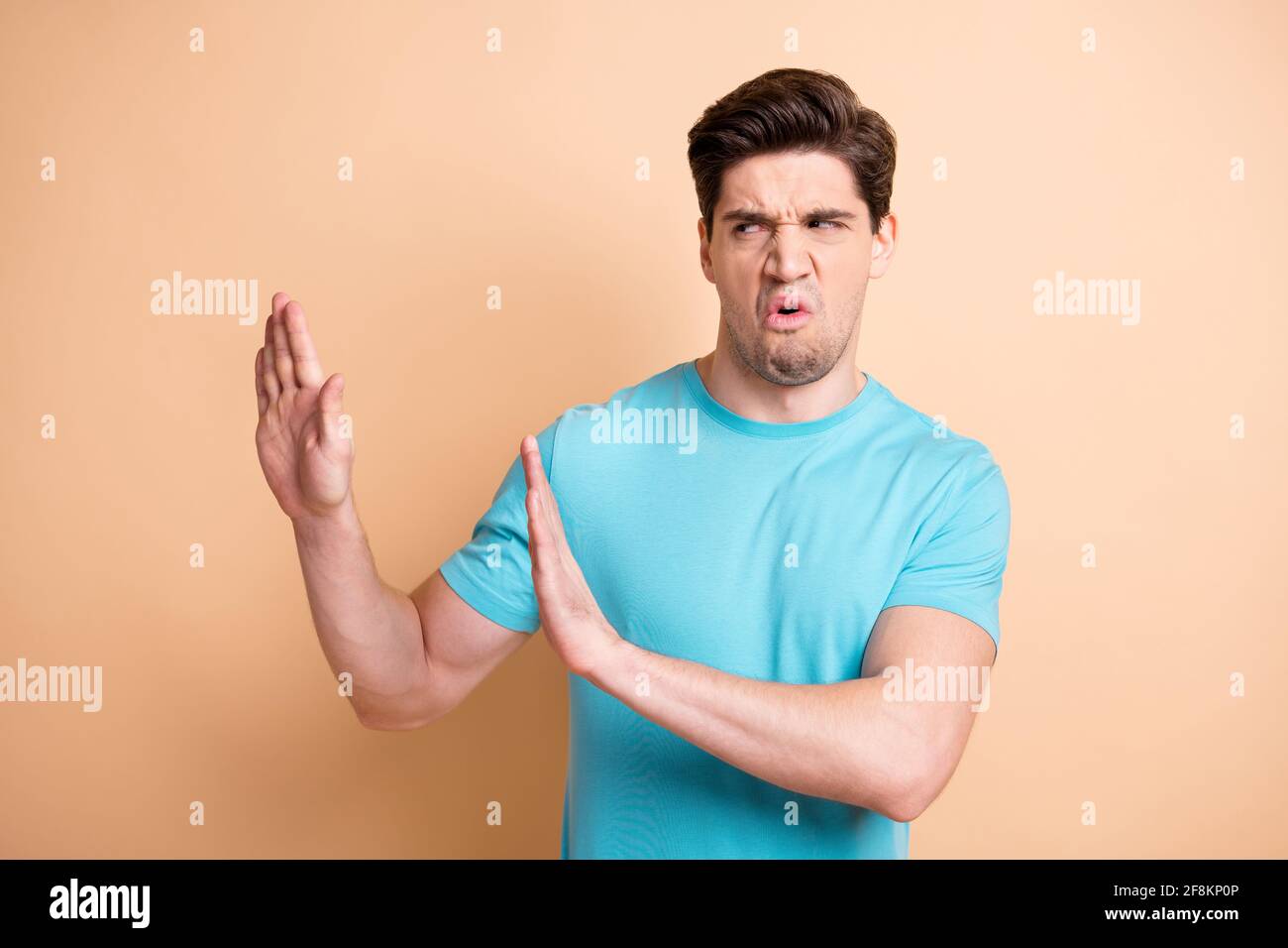 Portrait of attractive displeased guy showing stop sign aside disgust ...