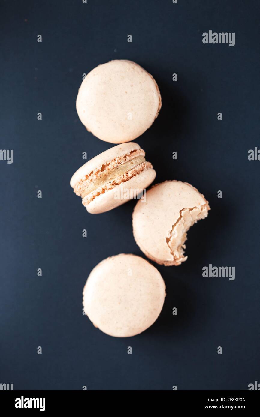 Light cream and chocolate macaroons on black background Stock Photo - Alamy