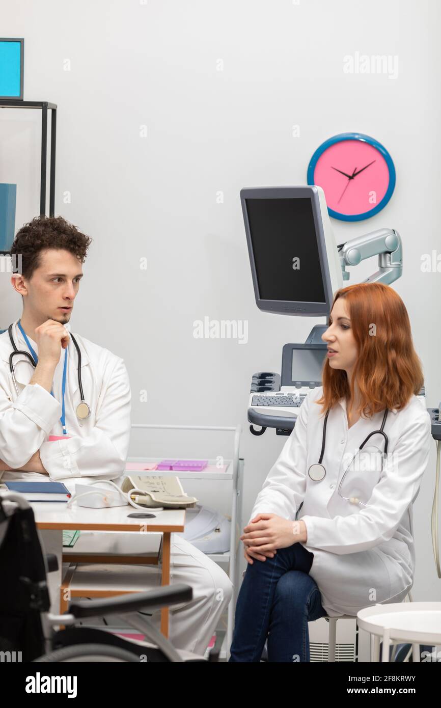 A young doctor talks to a redheaded intern about his next patient. GP ...