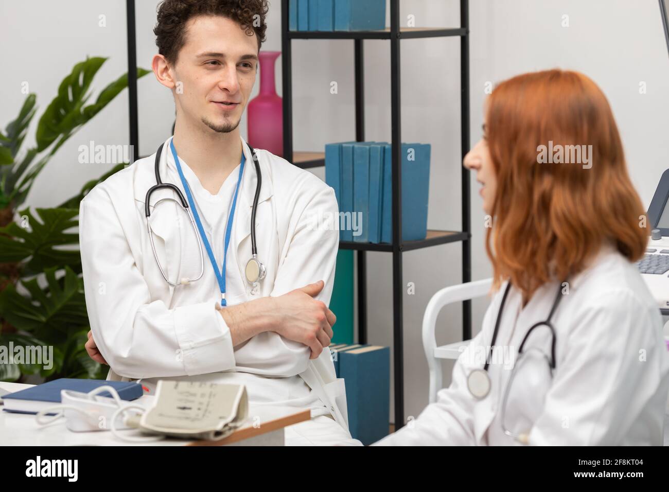 A young doctor talks to a redheaded intern about his next patient. GP ...