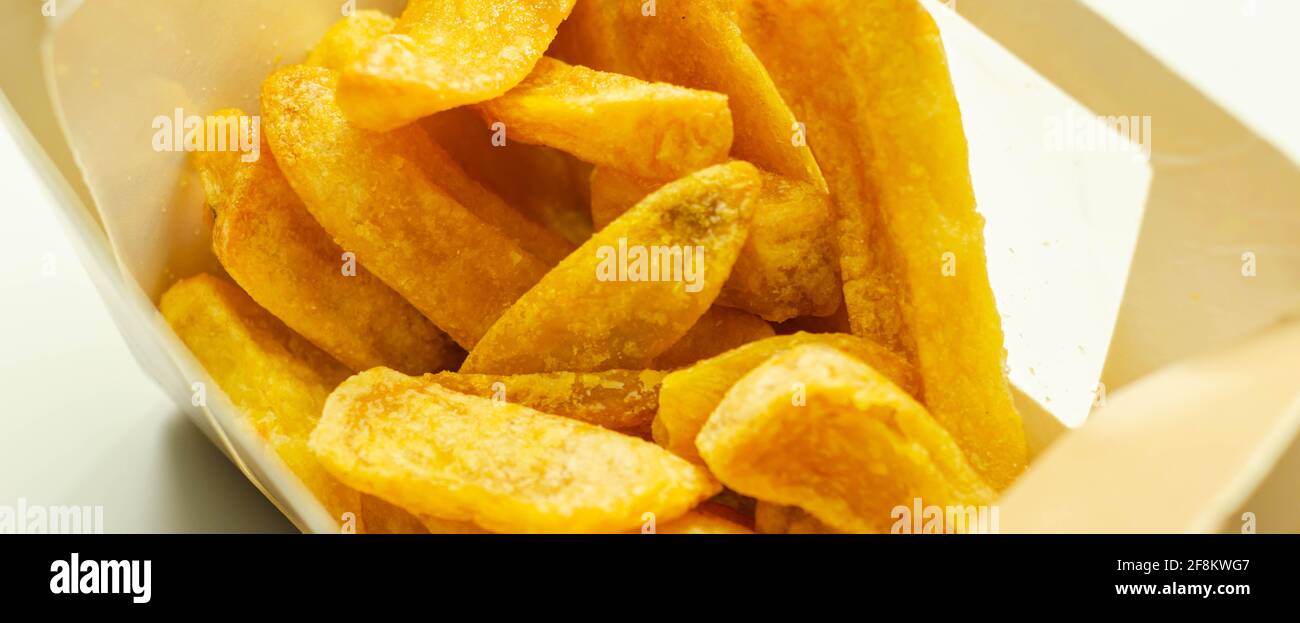 Deep fried and crispy delicious fries in a cardboard box, take away ...