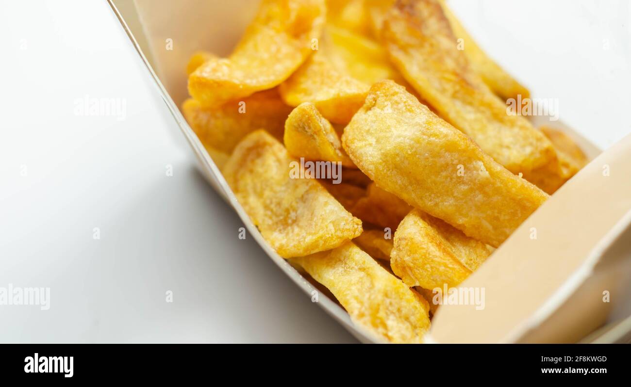 Deep fried and crispy delicious fries in a cardboard box, take away ...