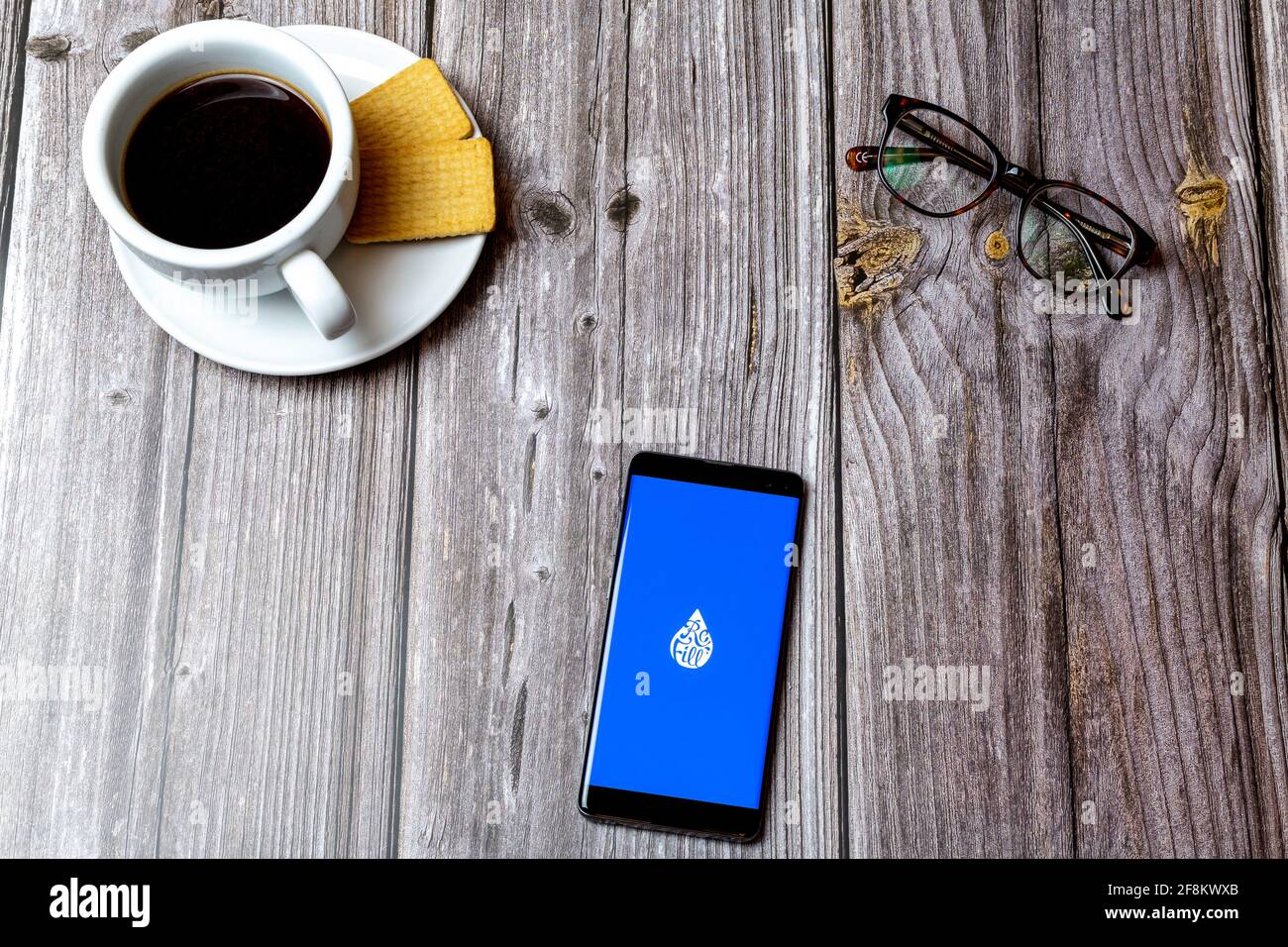 A Mobile phone or cell phone laid on a wooden table showing the Refill ...