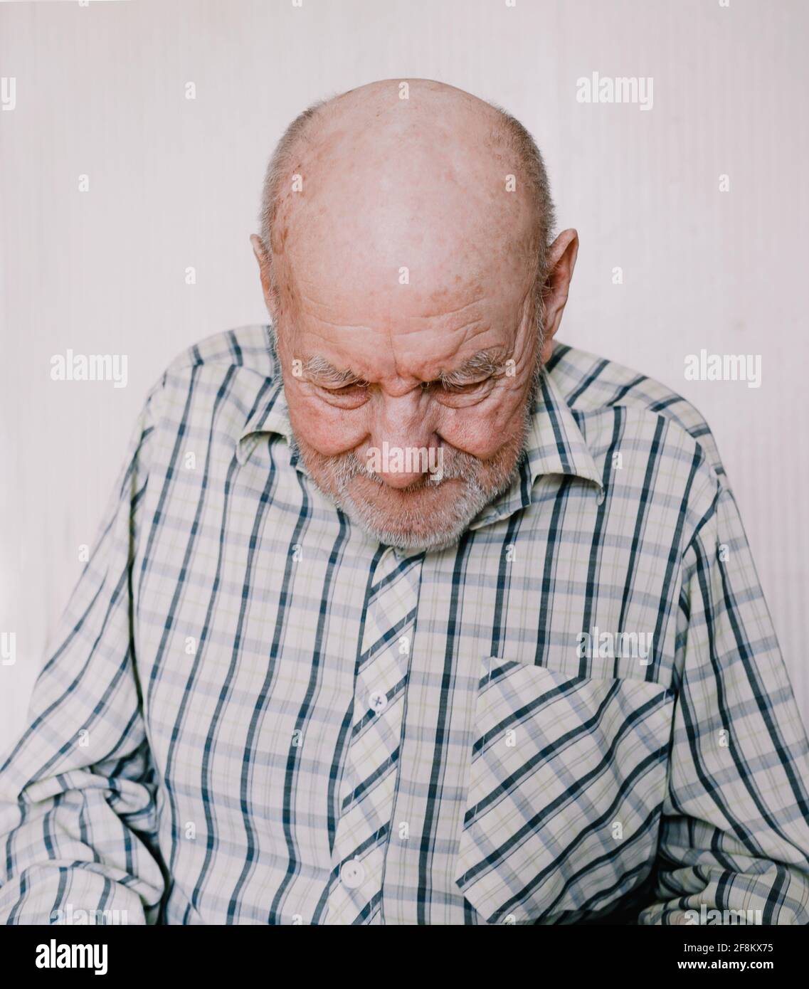 a large portrait of an old man on a light background with deep wrinkles ...