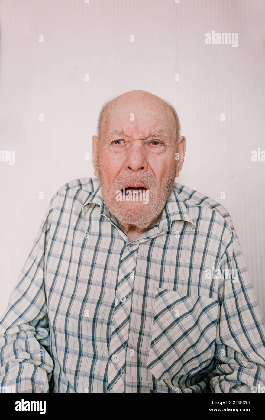 a large portrait of an old man on a light background with deep wrinkles ...