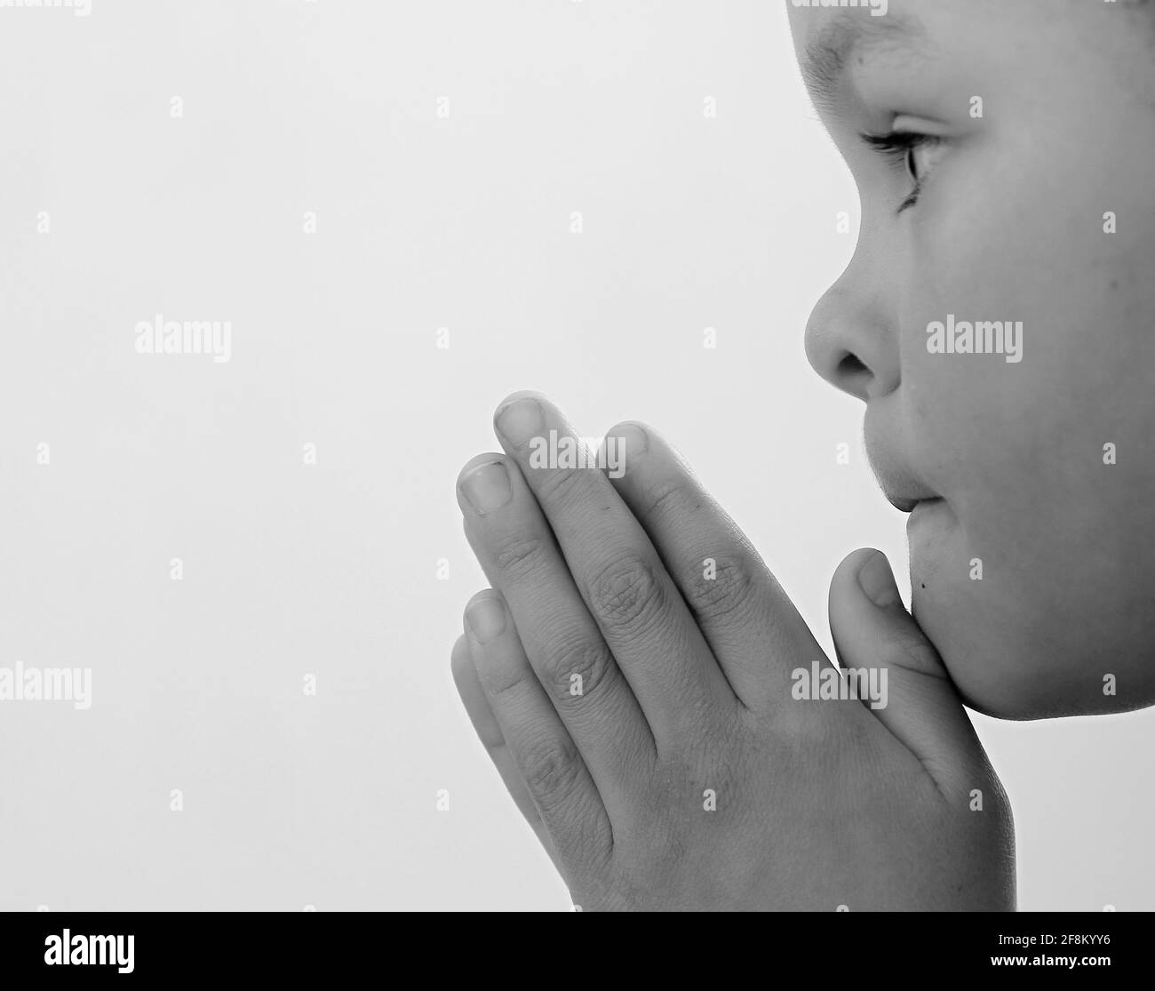 boy praying to God with hands together stock photo Stock Photo - Alamy