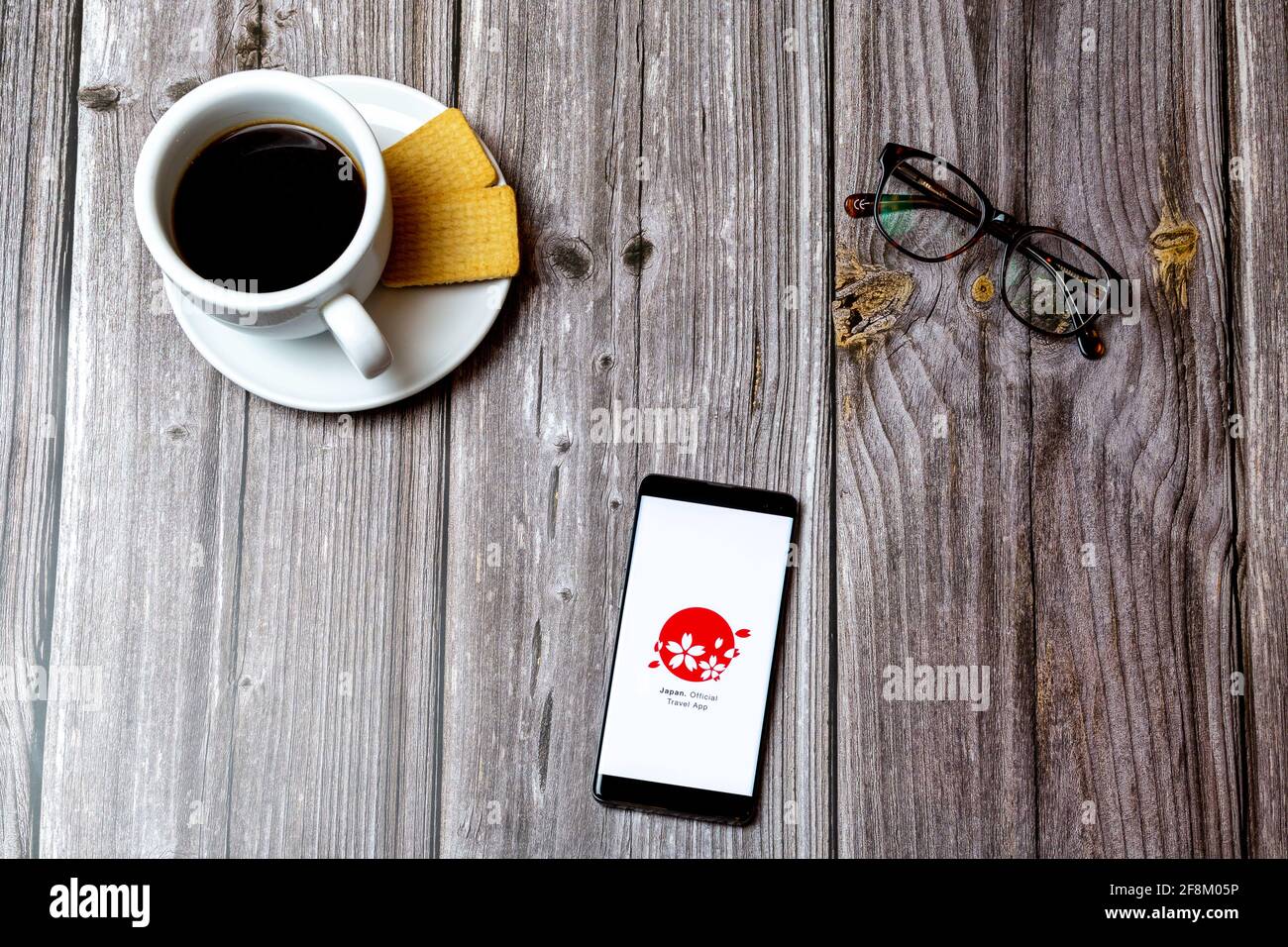 A Mobile phone or cell phone laid on a wooden table showing the japan ...