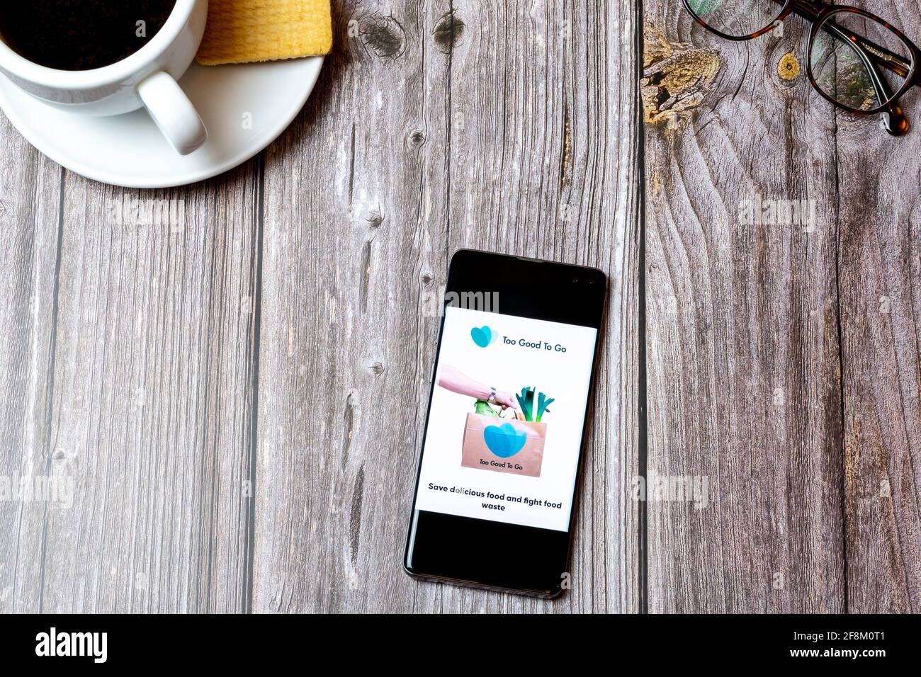 A Mobile phone or cell phone laid on a wooden table showing the Too ...