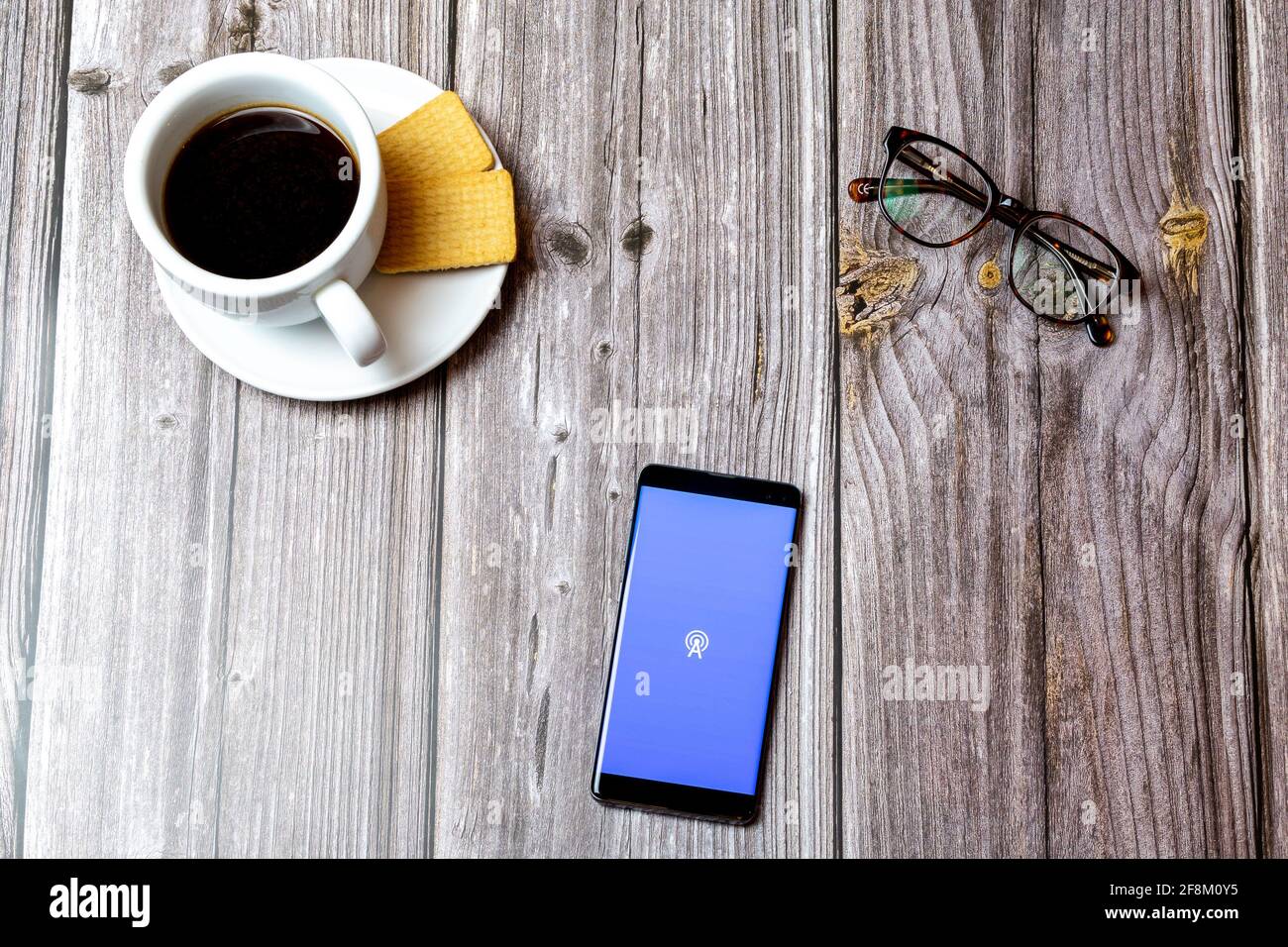 A Mobile phone or cell phone laid on a wooden table showing the ...