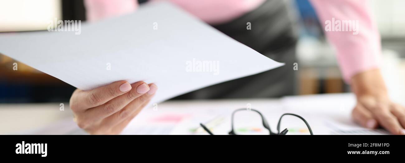 Female hands hold documents on table are commercial charts and ...