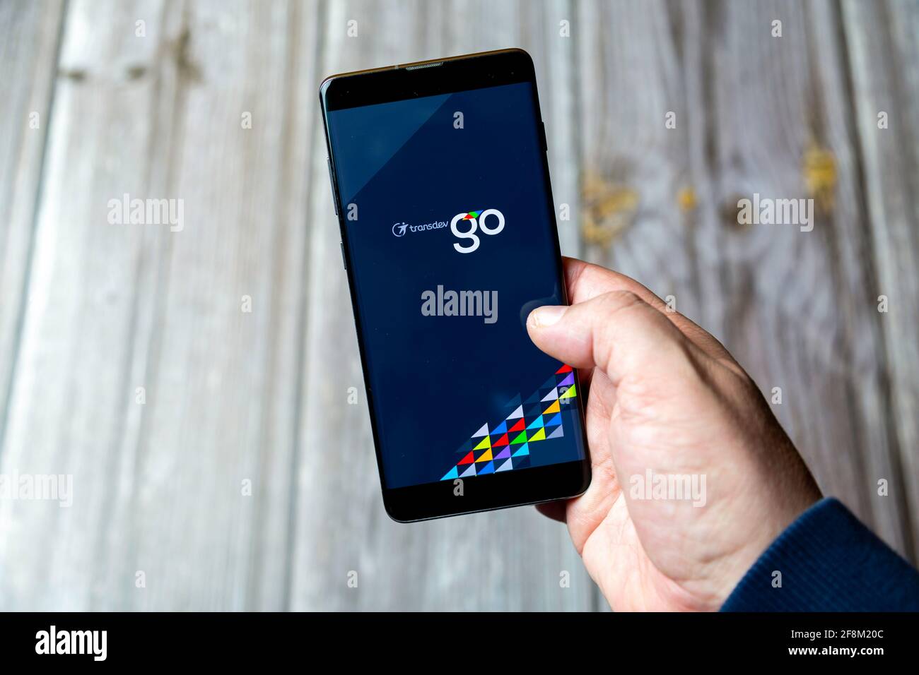 A Mobile phone or Cell phone being held in a hand showing the transdev Go app on screen Stock ...