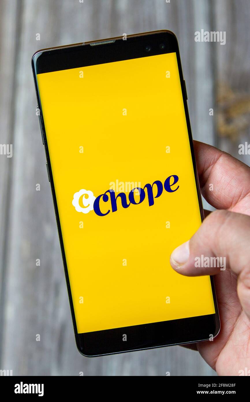 A Mobile phone or Cell phone being held in a hand showing the Chope app ...