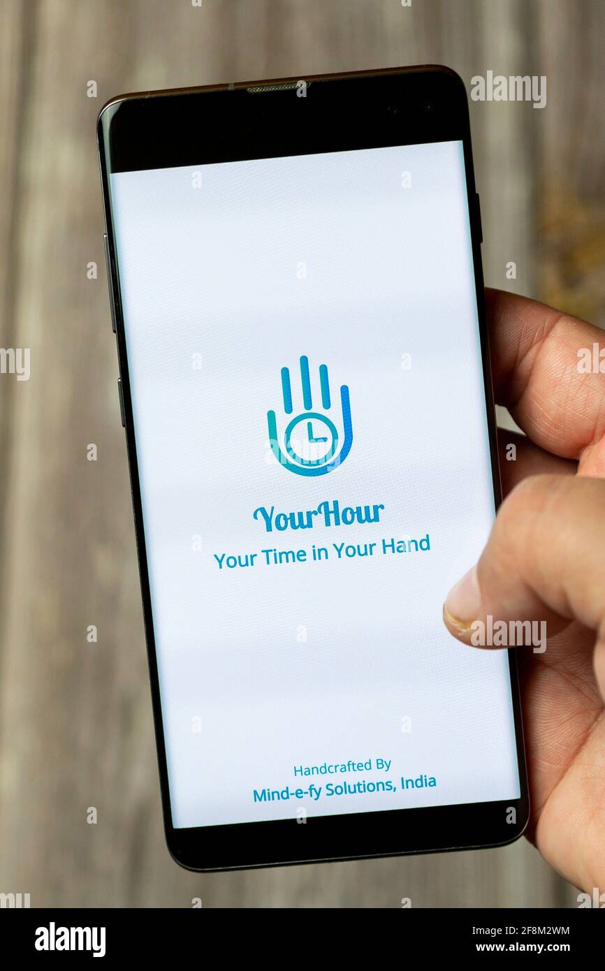 A Mobile phone or Cell phone being held in a hand showing the yourhour ...