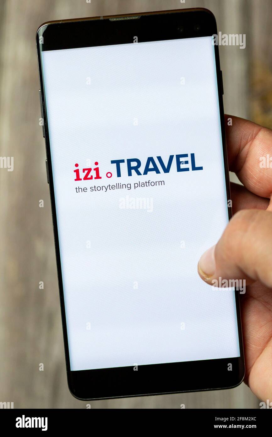 A Mobile phone or Cell phone being held in a hand showing the izi ...