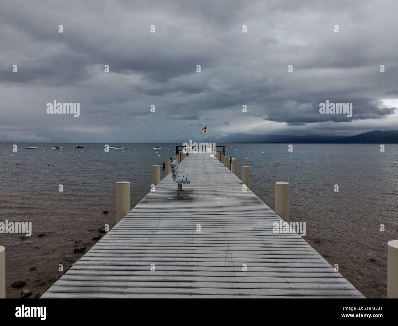 Closeup view of a bench on the dock with pier support on the ocean on a ...