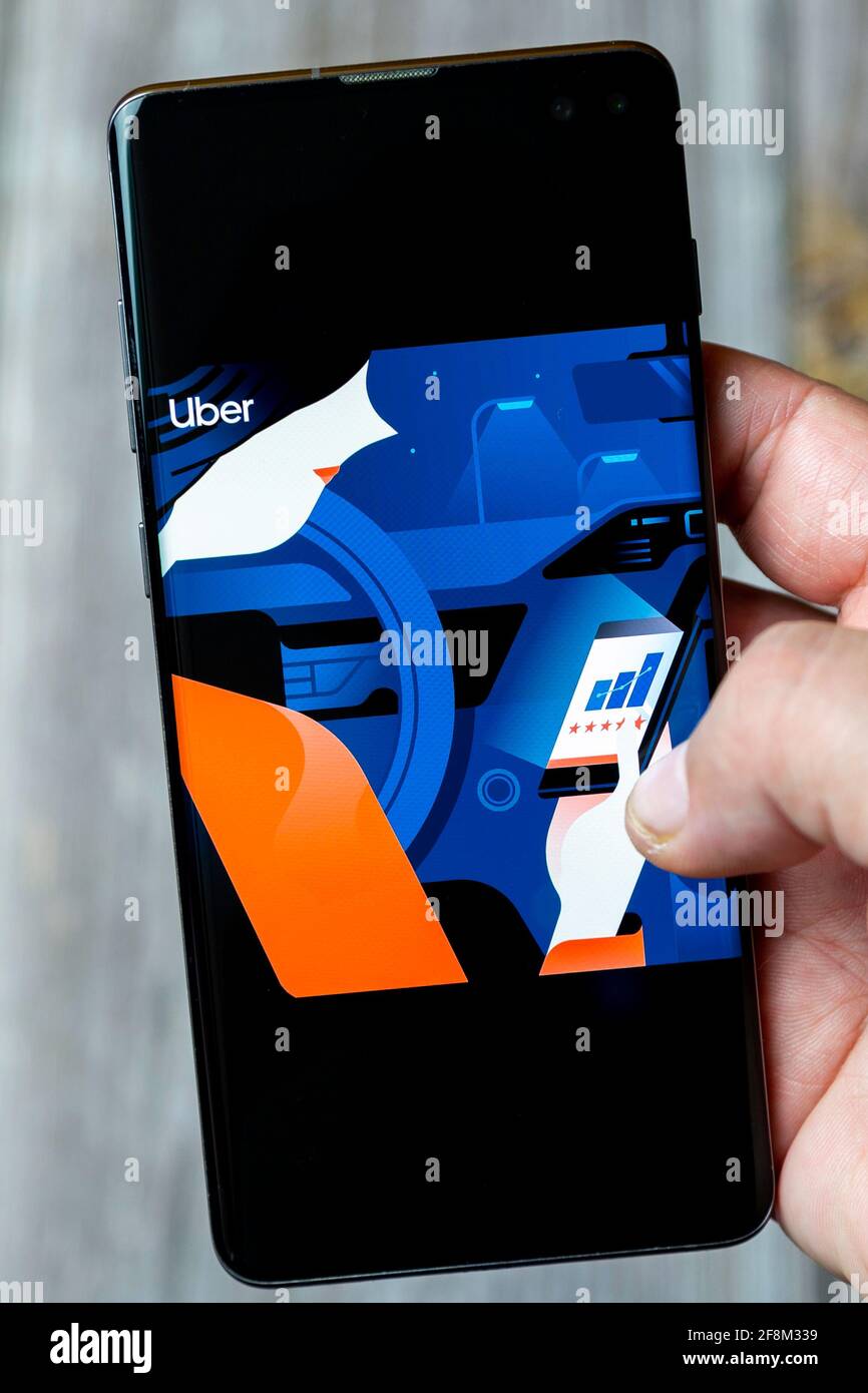 A Mobile phone or Cell phone being held in a hand showing the Uber ...