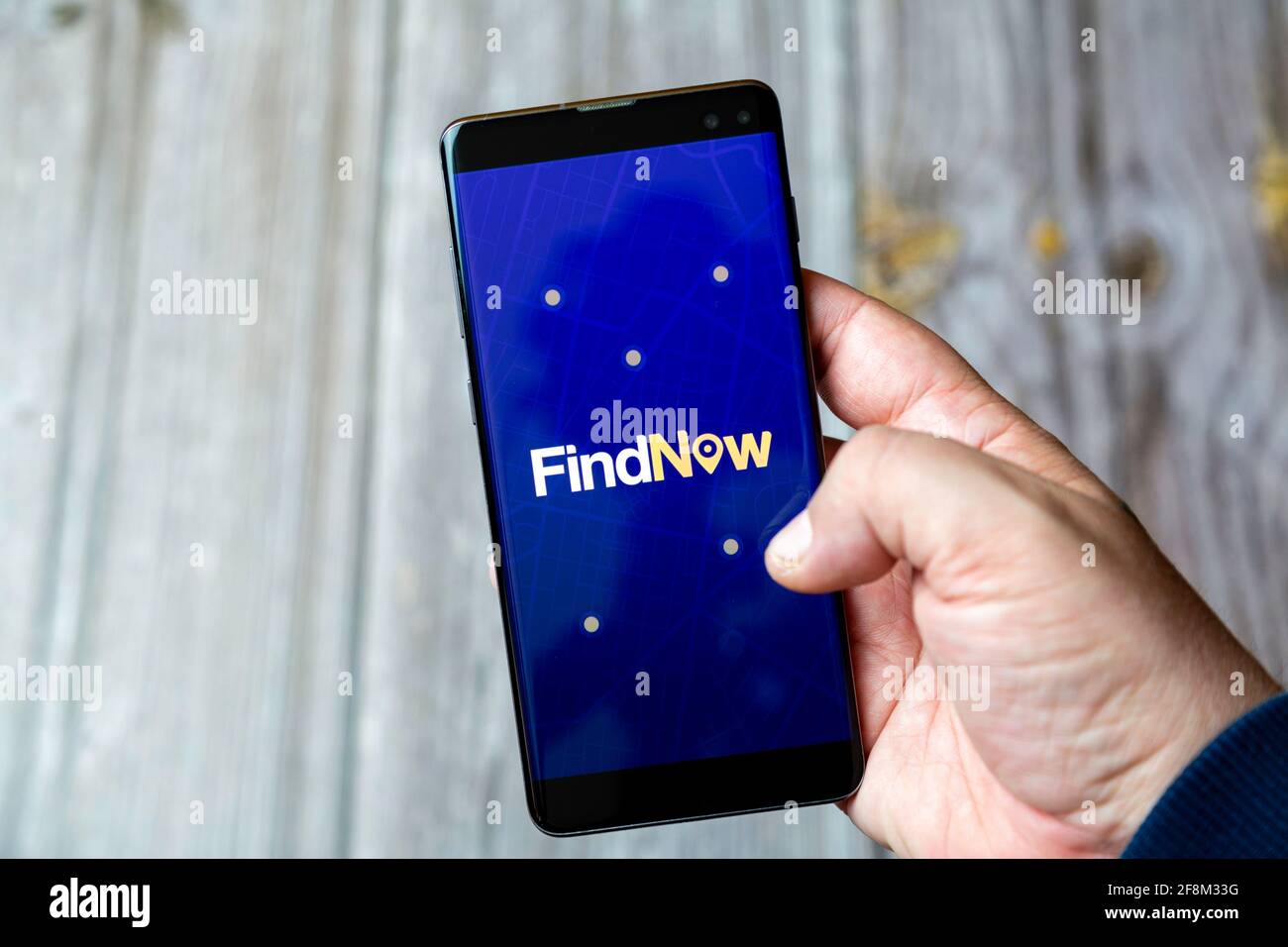 A Mobile phone or Cell phone being held in a hand showing the Findnow ...
