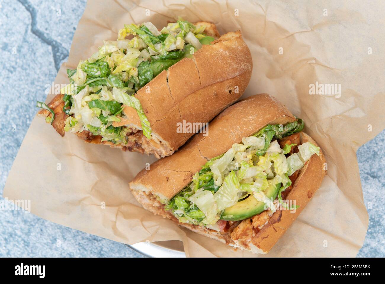 Overhead view of BBQ chicken sandwich loaded with sauce, bacon, avocado ...
