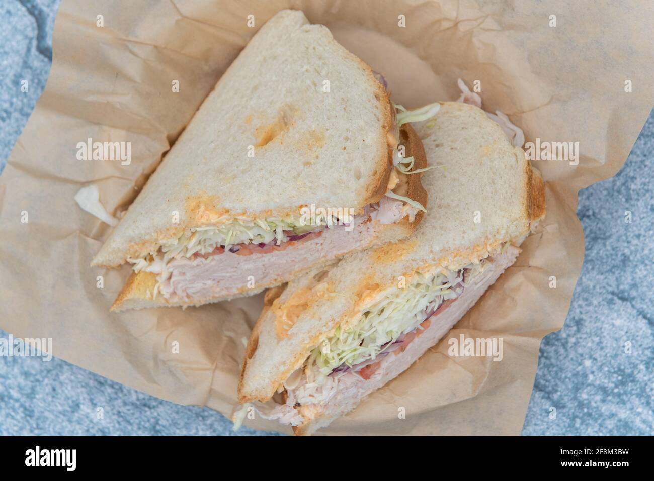 Overhead view of roasted turkey sandwich stacked inside sour dough ...