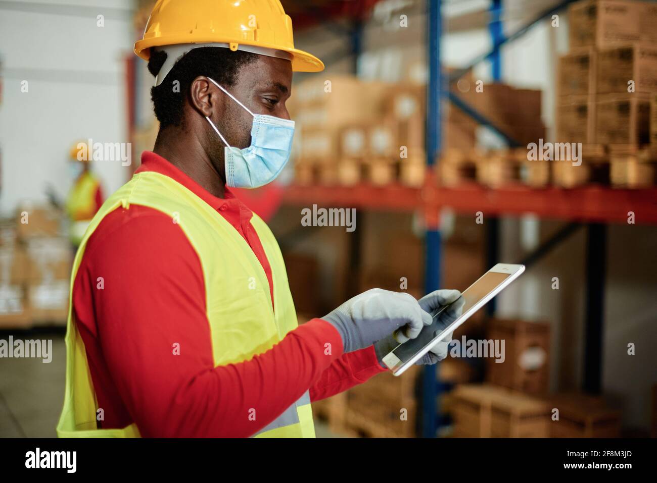 Caucasian adult warehouse worker checks delivery order on a tablet ...