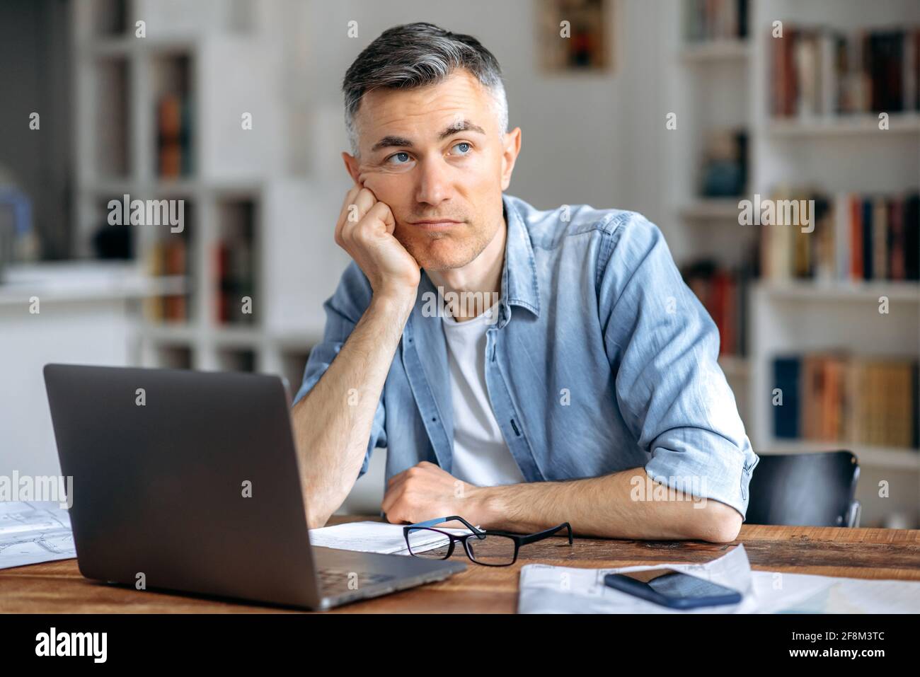 Middle aged caucasian business man or freelancer sitting at workplace ...