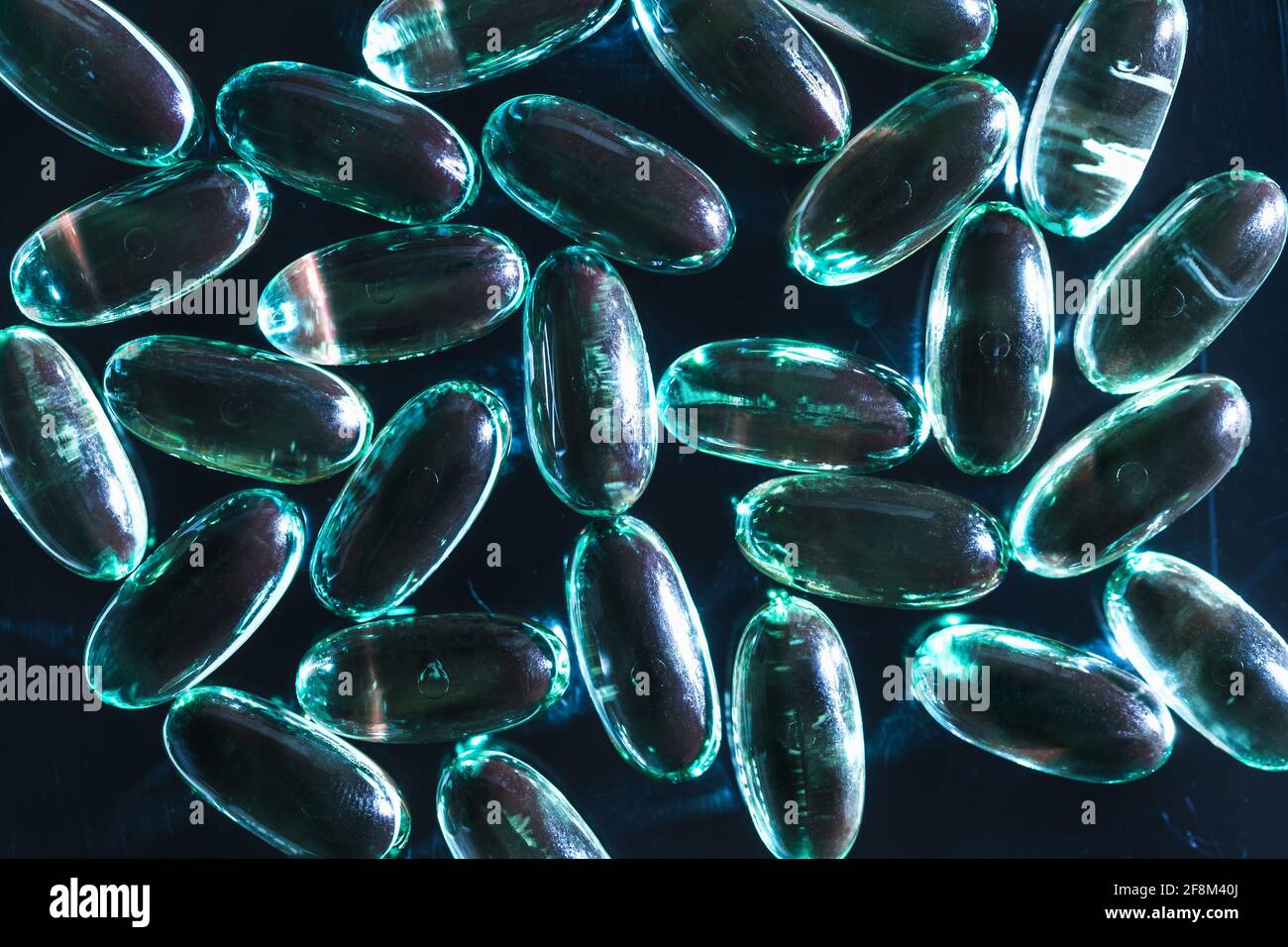 Shiny gel medication capsules on dark background Stock Photo - Alamy