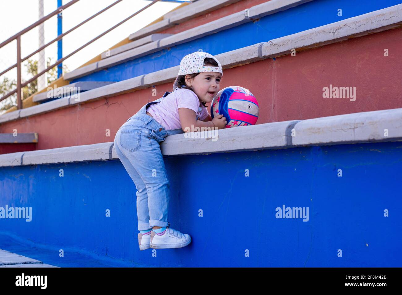 A small, Caucasian girl, climbing some steps where she was climbing ...