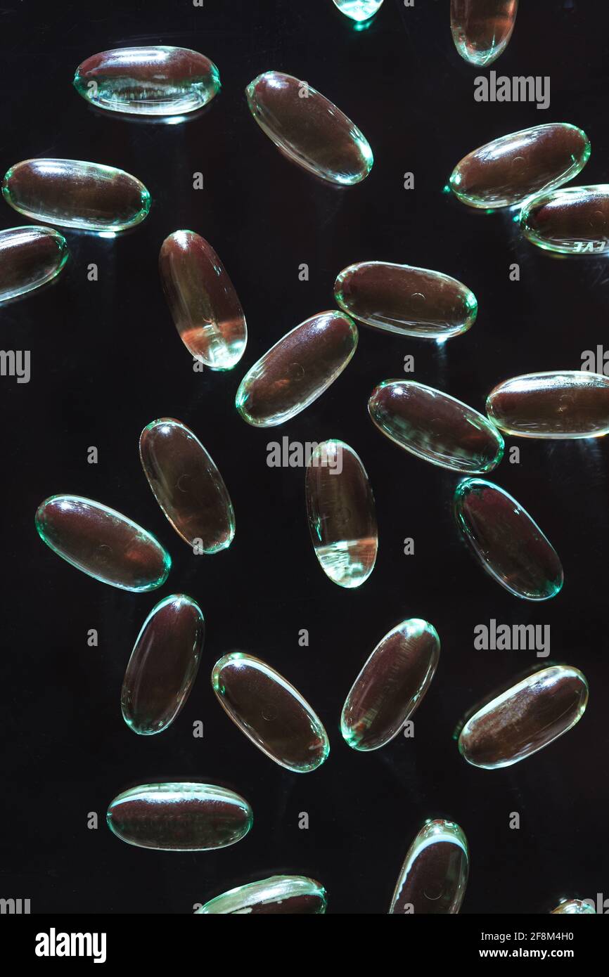 Shiny gel medication capsules on dark background Stock Photo - Alamy