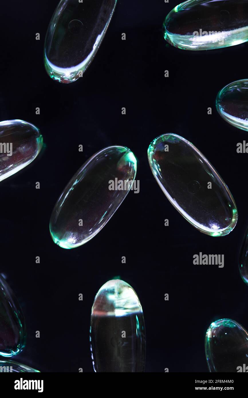 Shiny gel medication capsules on dark background Stock Photo - Alamy