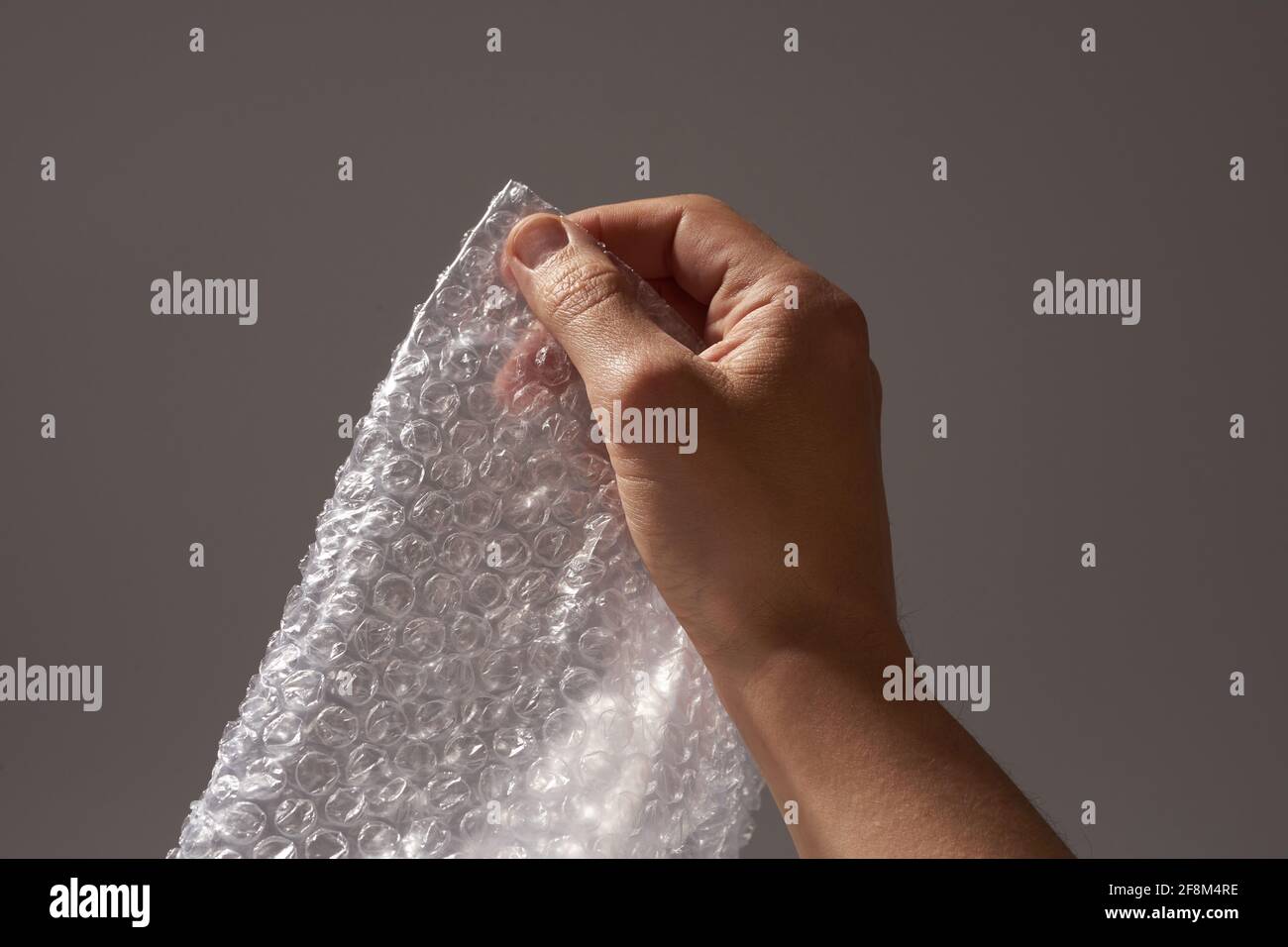 Male hand popping bubbles of bubble wrap Stock Photo - Alamy